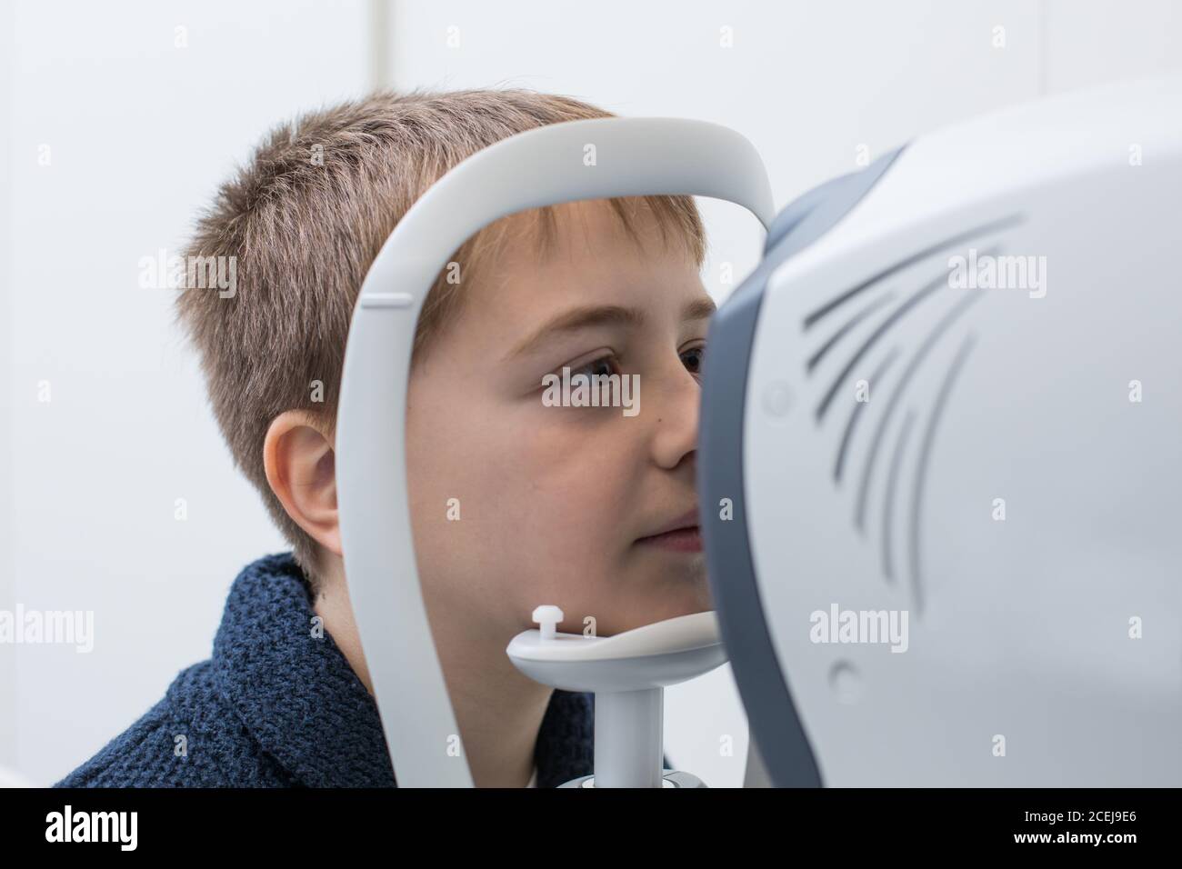 Optician testing a boy's eyes with optometry devices Stock Photo - Alamy
