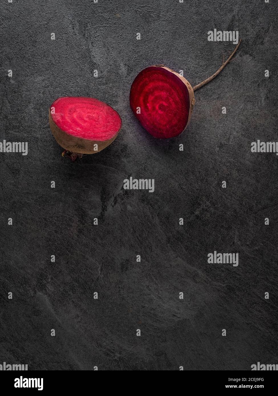 Beetroot cut in half on dark table. Overhead shot with copy space ...