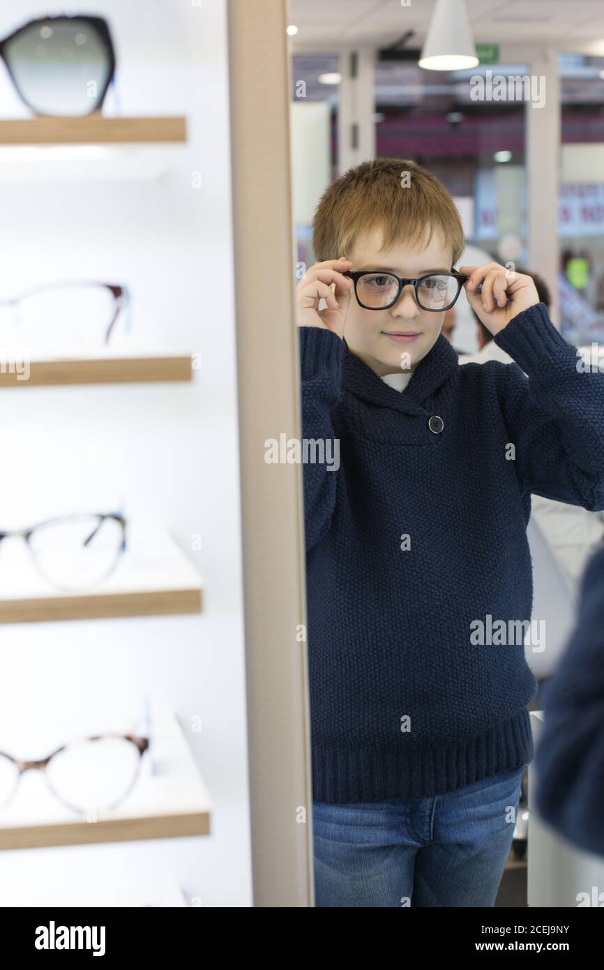 Cute young boy trying on glasses in an eyewear store Stock Photo - Alamy