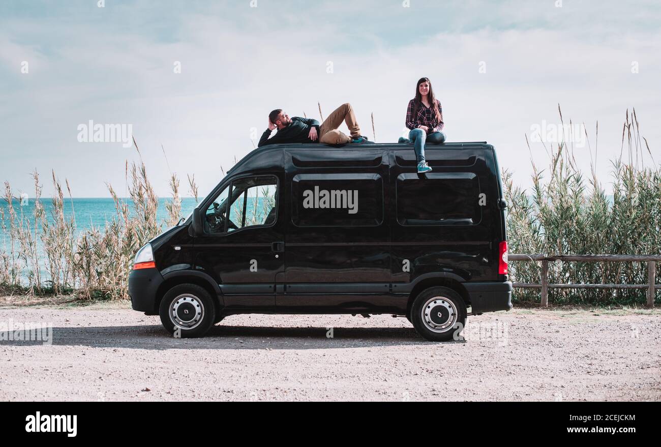 Couple at van at seaside Stock Photo - Alamy