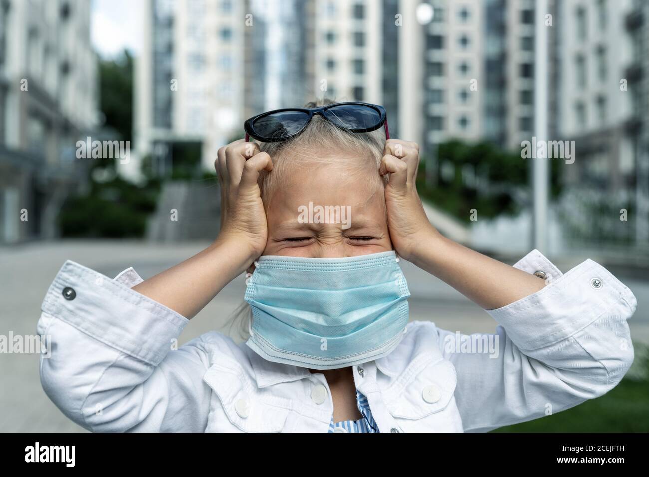 Little blond caucasian girl wearing protective face mask feel stressed ...