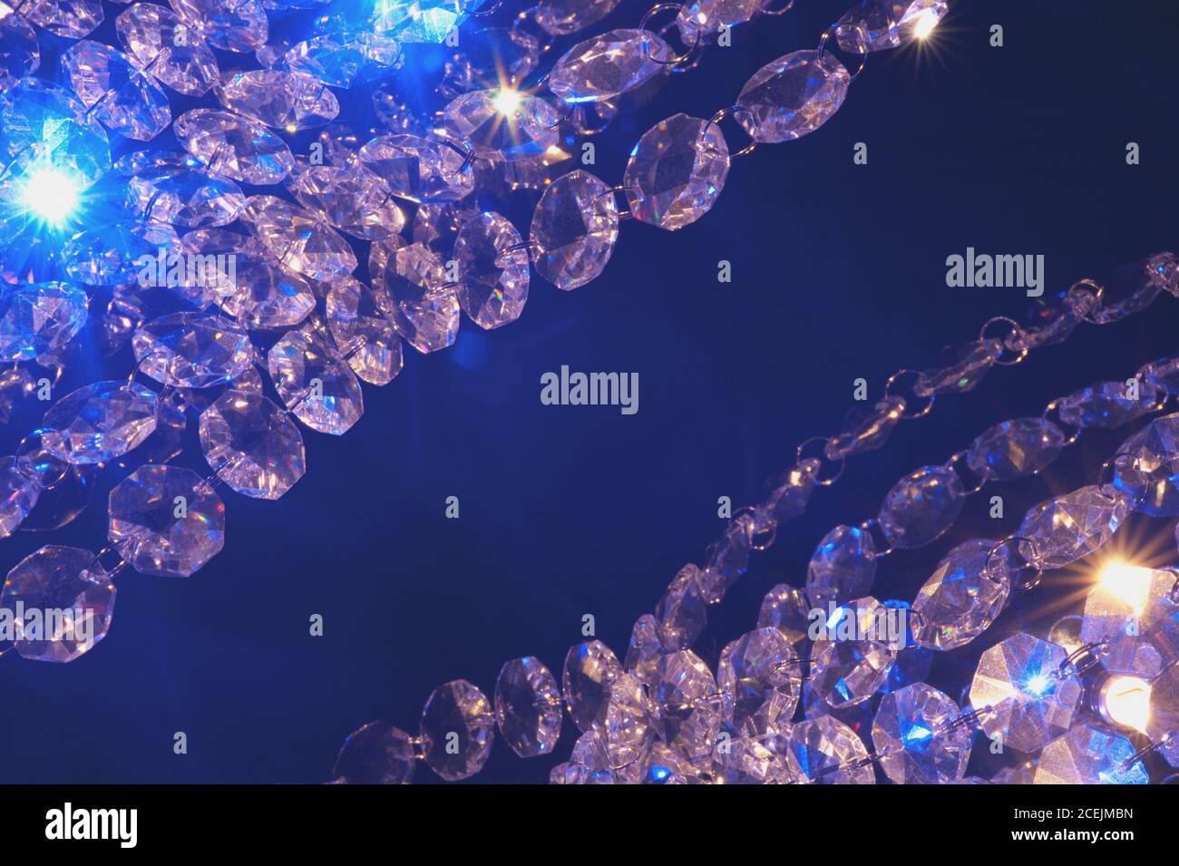 Bright illumination of shiny diamonds in lights on dark blue background ...