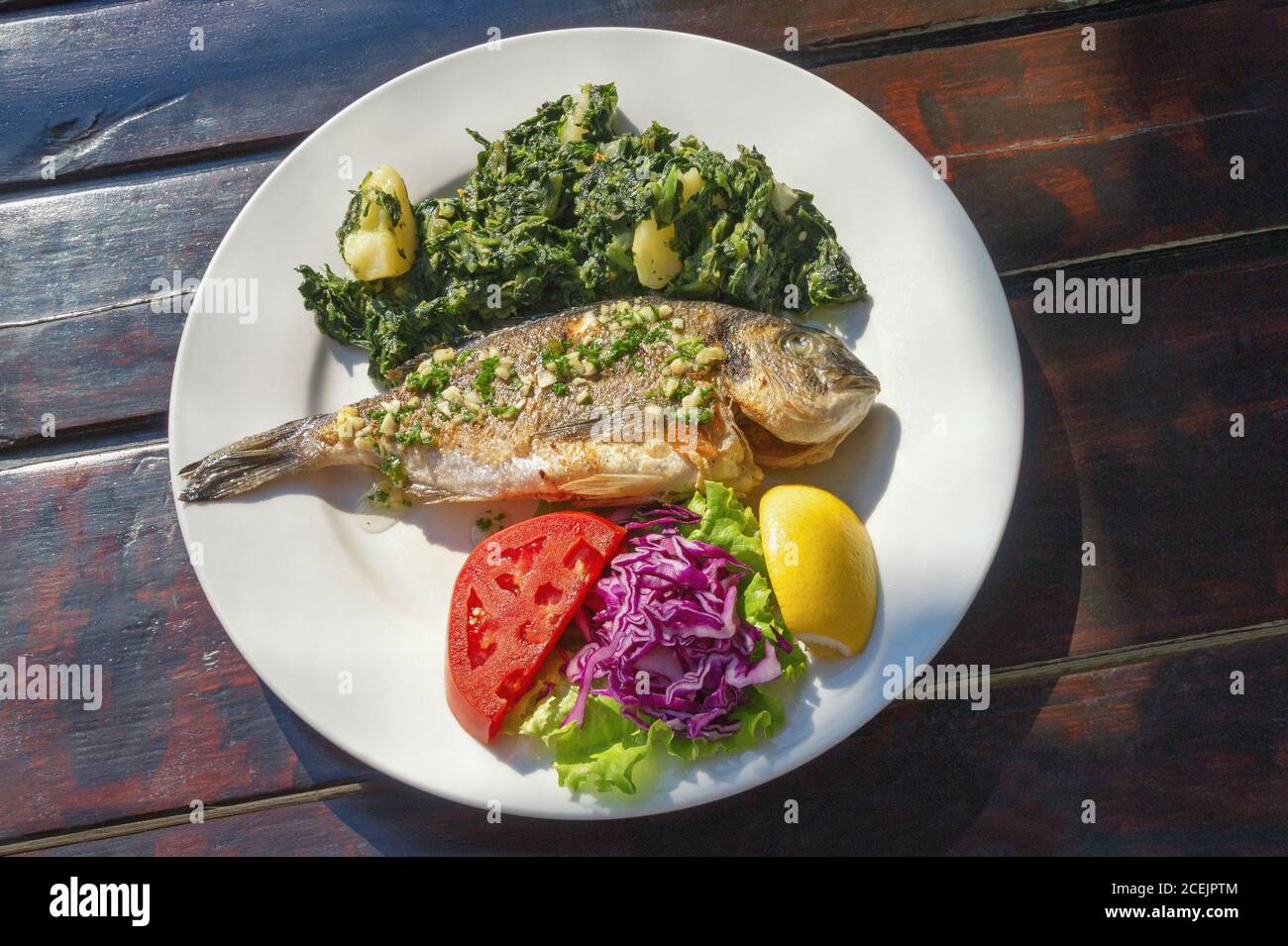 Balkan cuisine. Grilled fish ( sea bream ) with vegetables and slice of ...