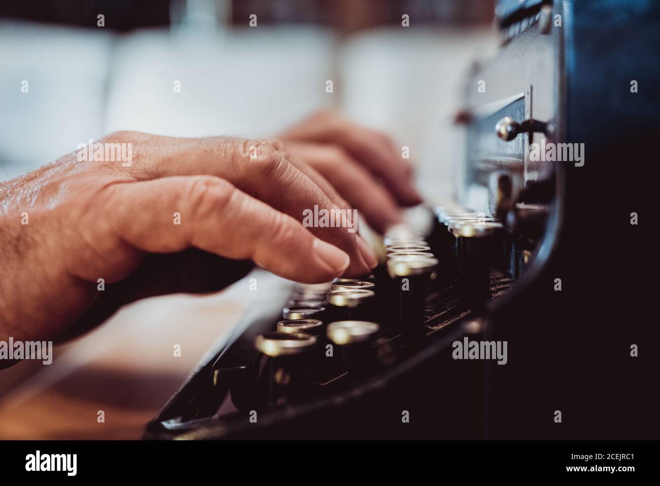 shot of hands of anonymous elderly person typing on keyboard of vintage ...