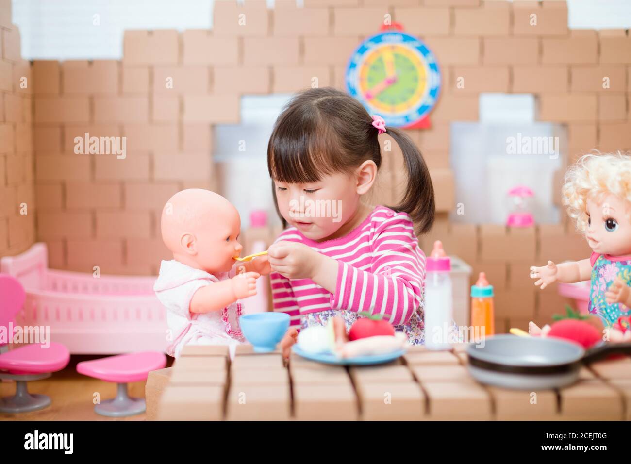 young girl pretend play babysitting with baby doll at home Stock Photo ...