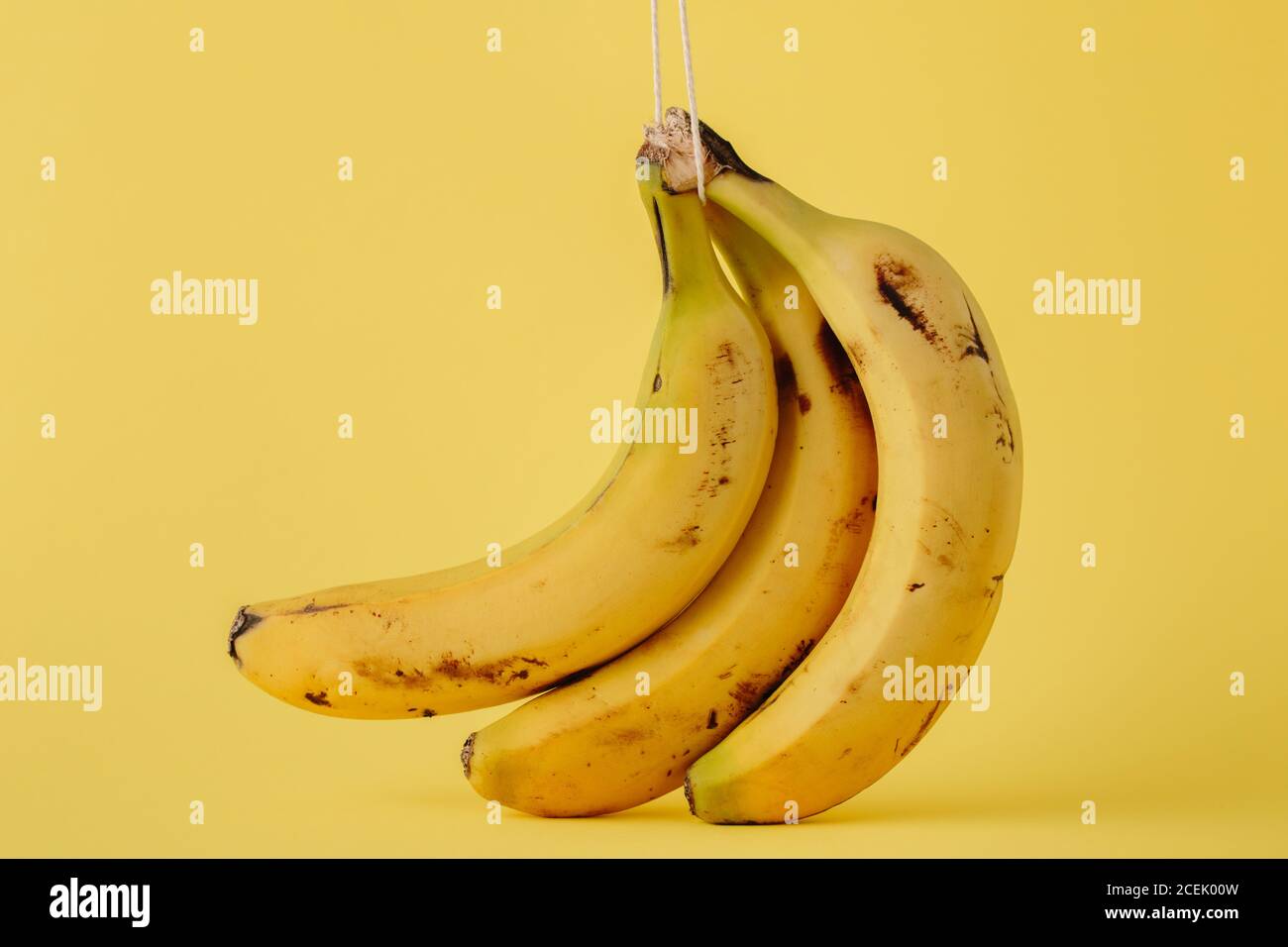 Bunch of ripe bright bananas lying on vivid yellow background Stock ...