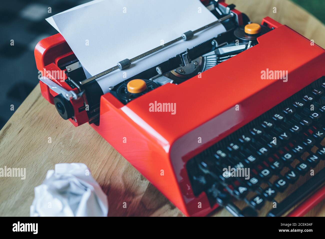 Close-up bright red typewriter with blank paper sheet inserted and ...