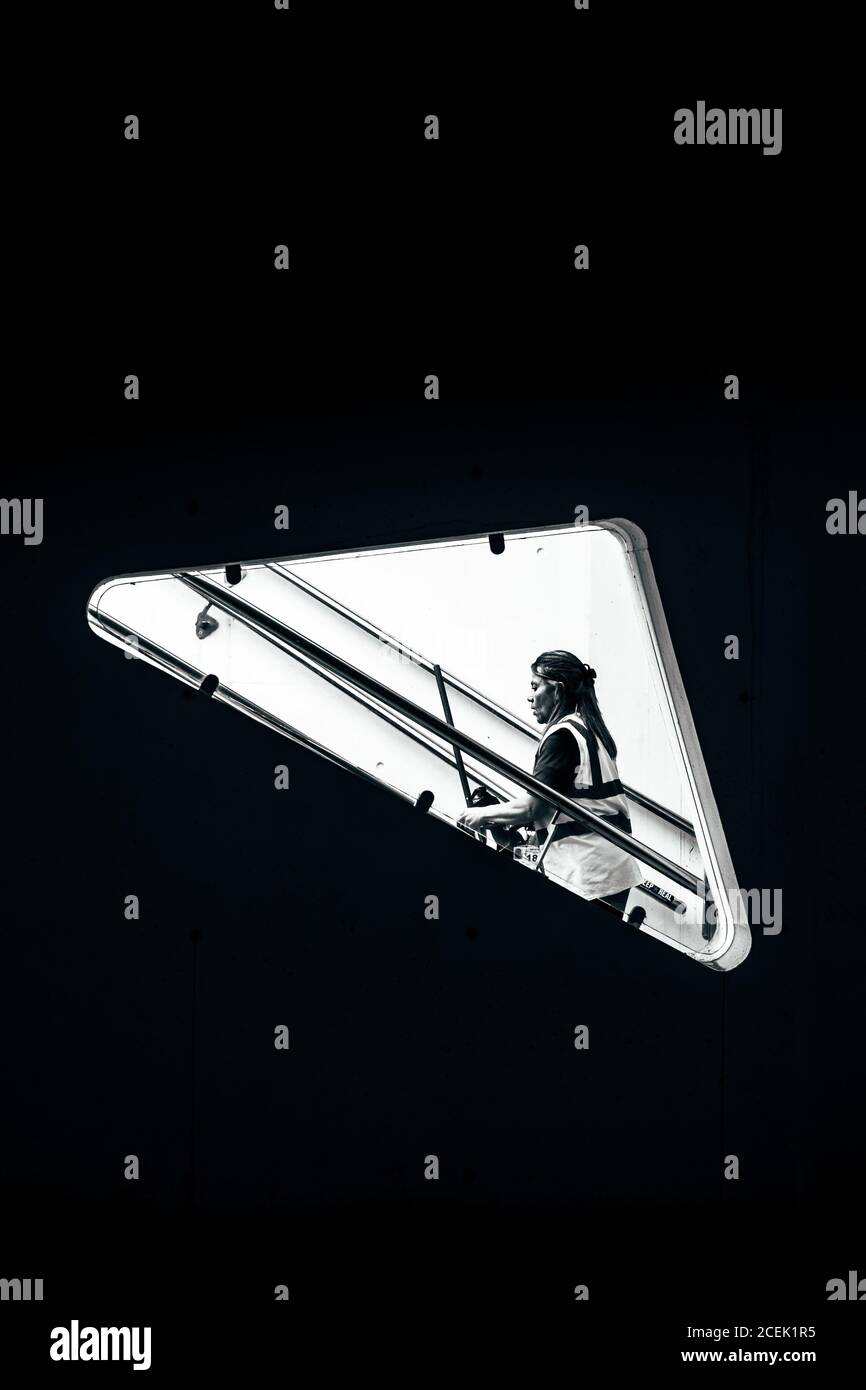 Black and white shot of beautiful female carrying object and walking up ...