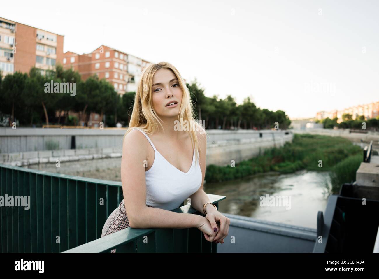 Young Woman leaning on bridge railing Stock Photo - Alamy