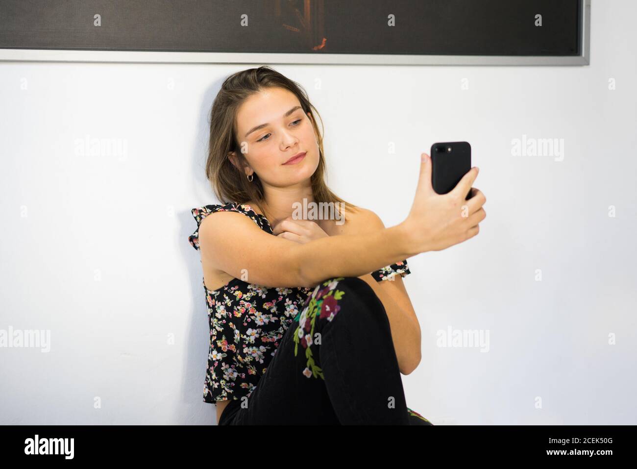 Woman taking selfie sitting on floor Stock Photo - Alamy