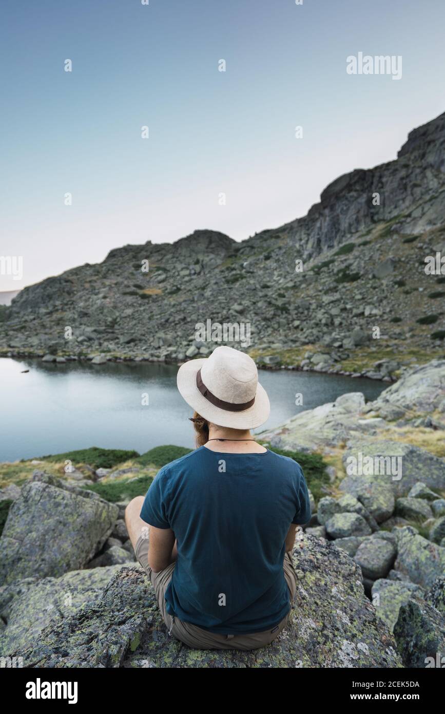 Young man sitting on the rocks hi-res stock photography and images - Alamy