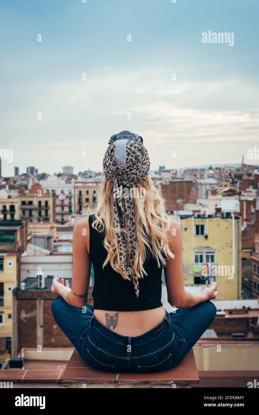 Young Woman sitting on rooftop Stock Photo - Alamy