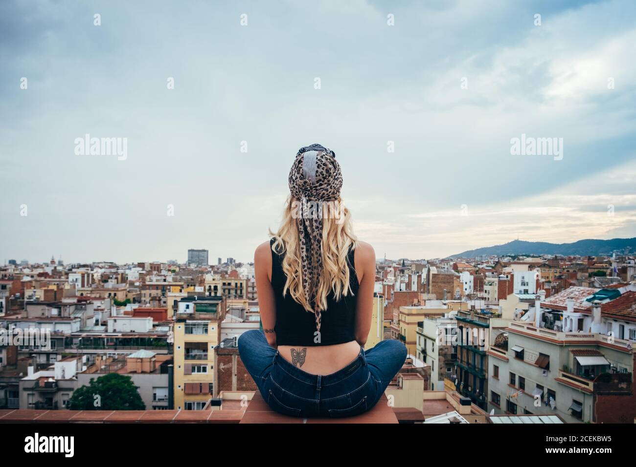 Young Woman sitting on rooftop Stock Photo - Alamy