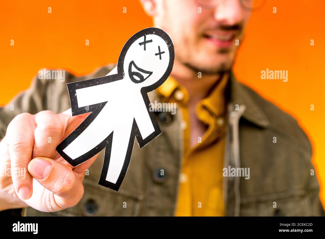 Happy guy showing paper silhouette for April fools day on orange ...