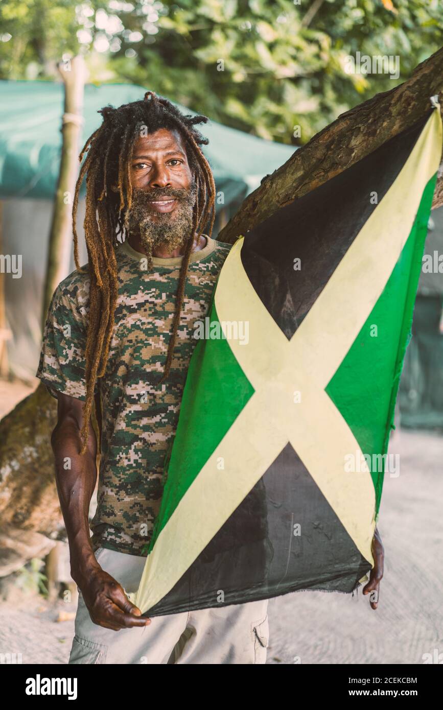Bearded young male driver in white shirt sitting in car parked on ...