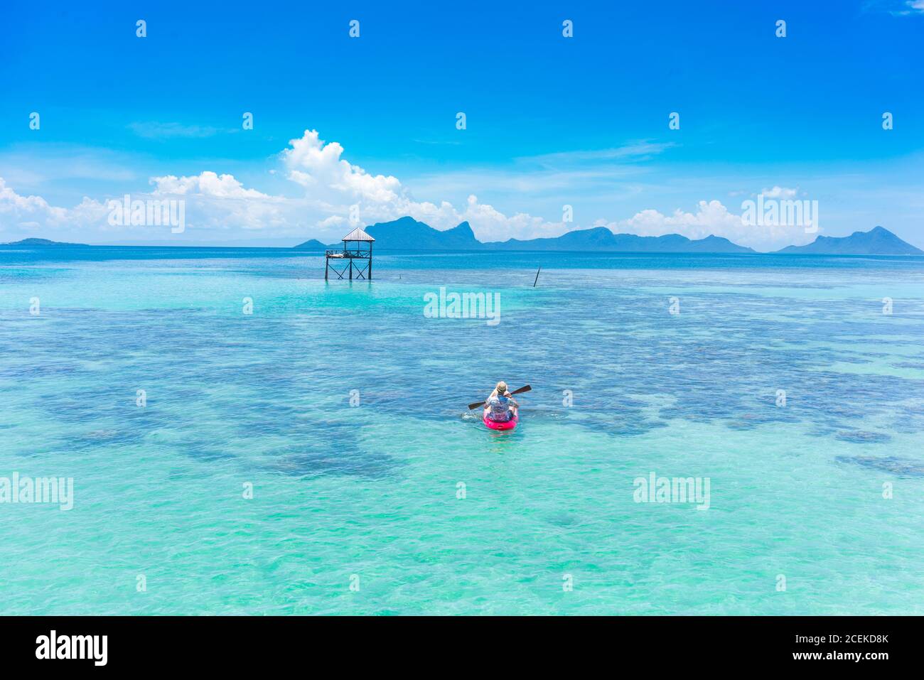 Back view male boating on canoe with paddle on amazing azure sea and ...