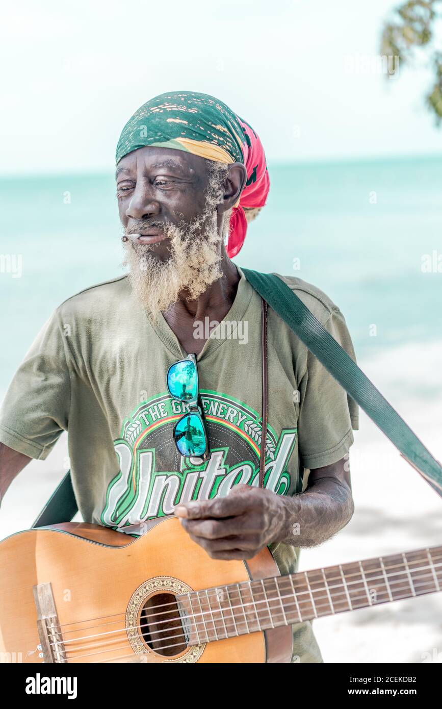 Jamaican man playing guitar Stock Photo - Alamy
