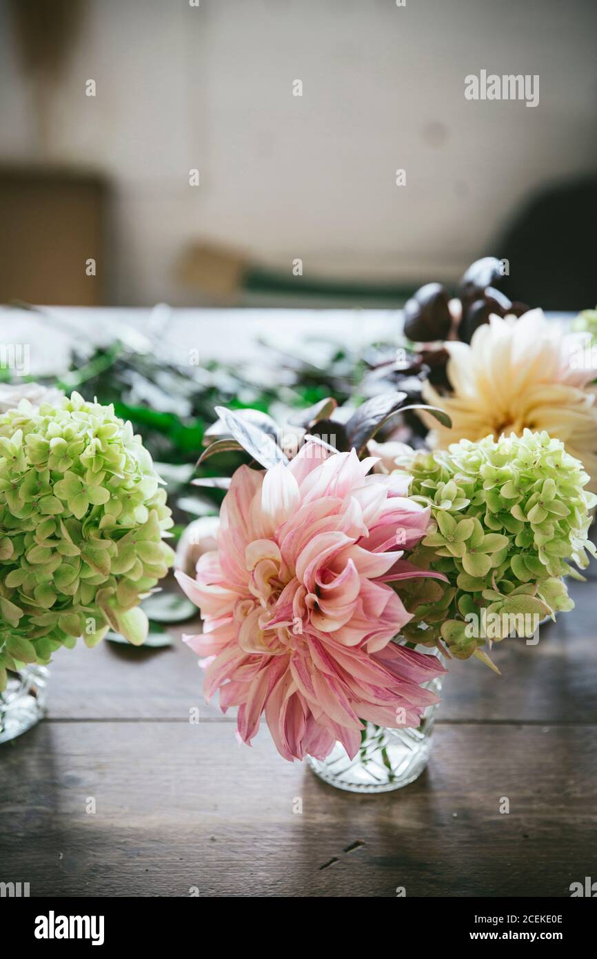 Wooden table with composition of fresh white hydrangea in glasses with ...