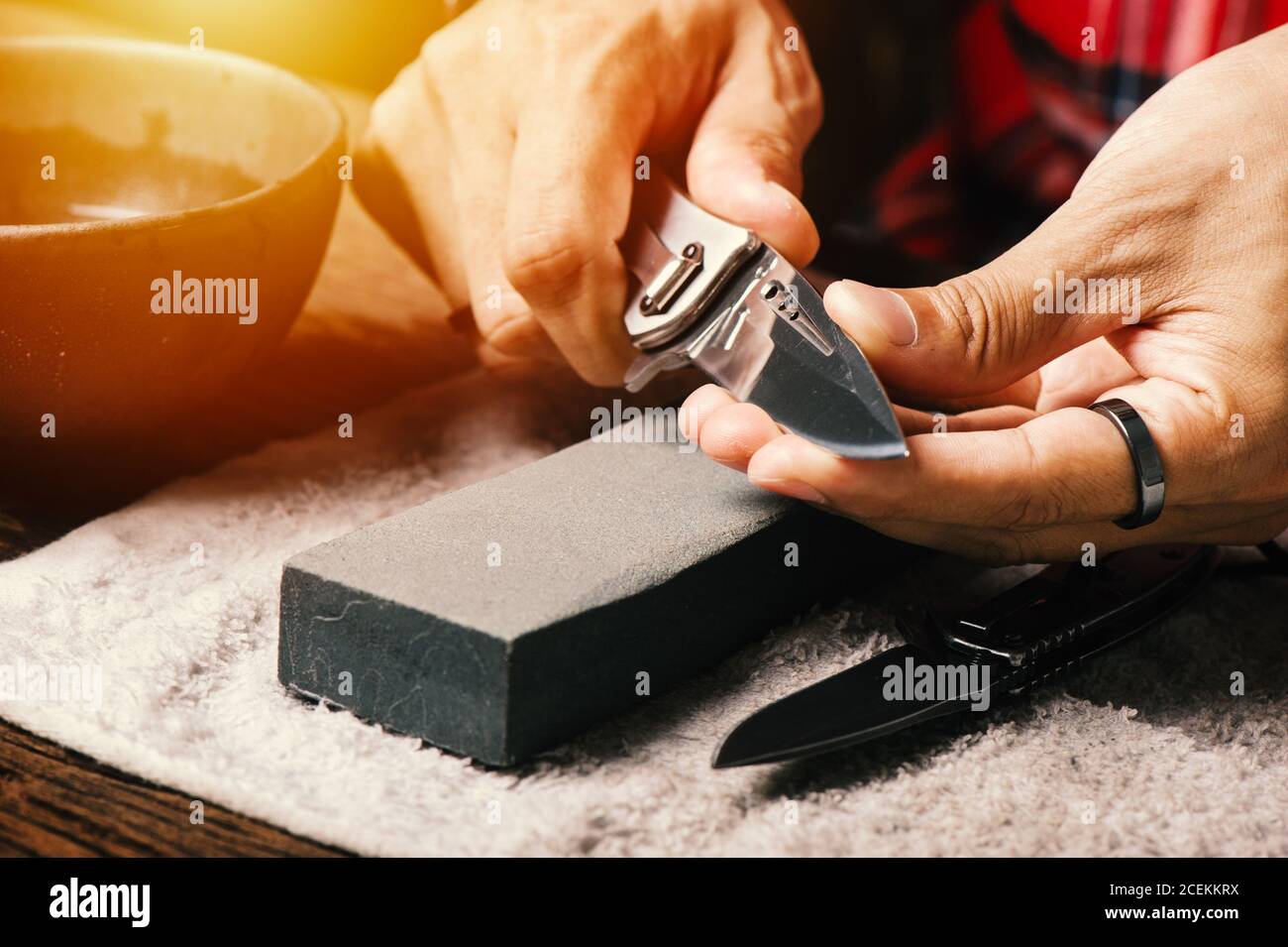 The man using whetstone to sharpening his pocket knife. Pocket knife ...