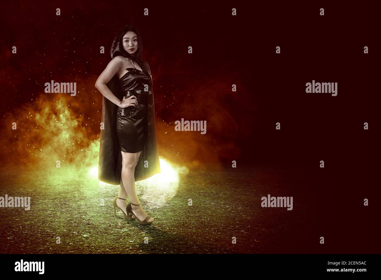 Asian witch woman with cloak standing with explosion background Stock ...