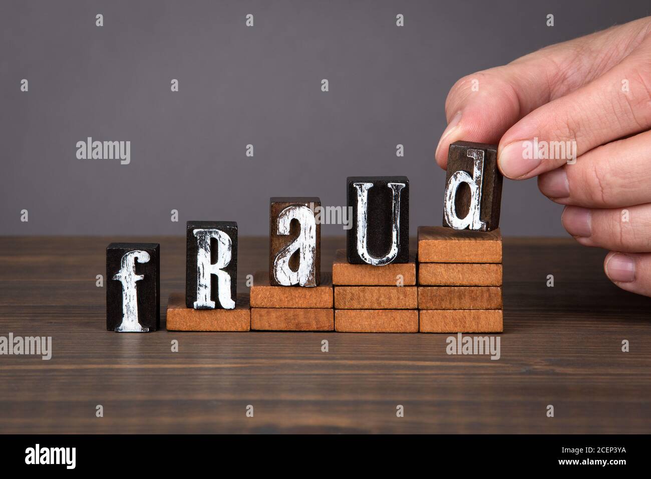 FRAUD concept. Wooden alphabet letters on steps. Gray background Stock ...