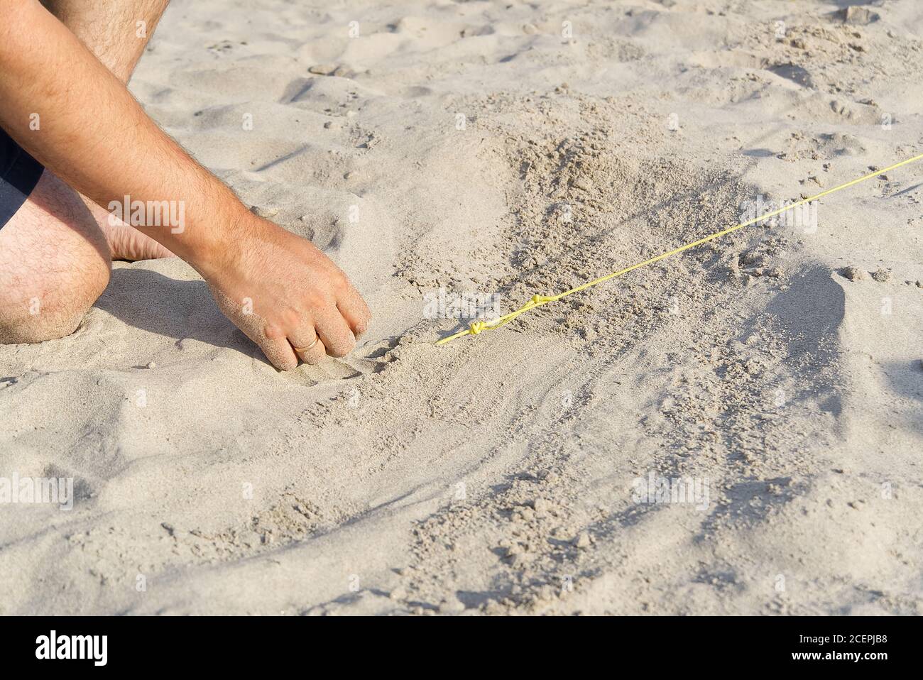a metal peg driven into the sand to pull the rope out of the tent ...