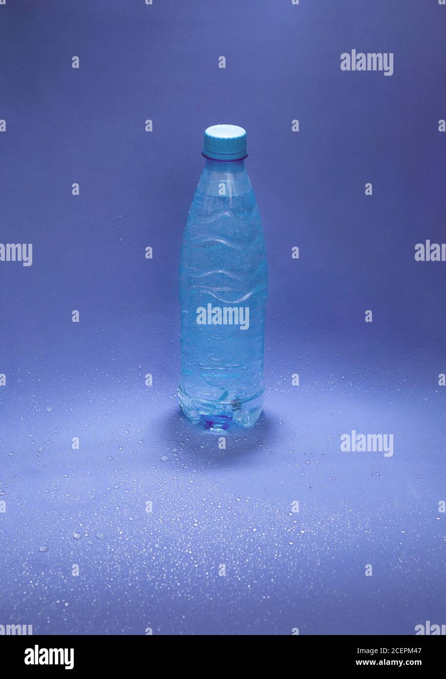 Blue plastic water bottle on a blue background with water drops Stock ...