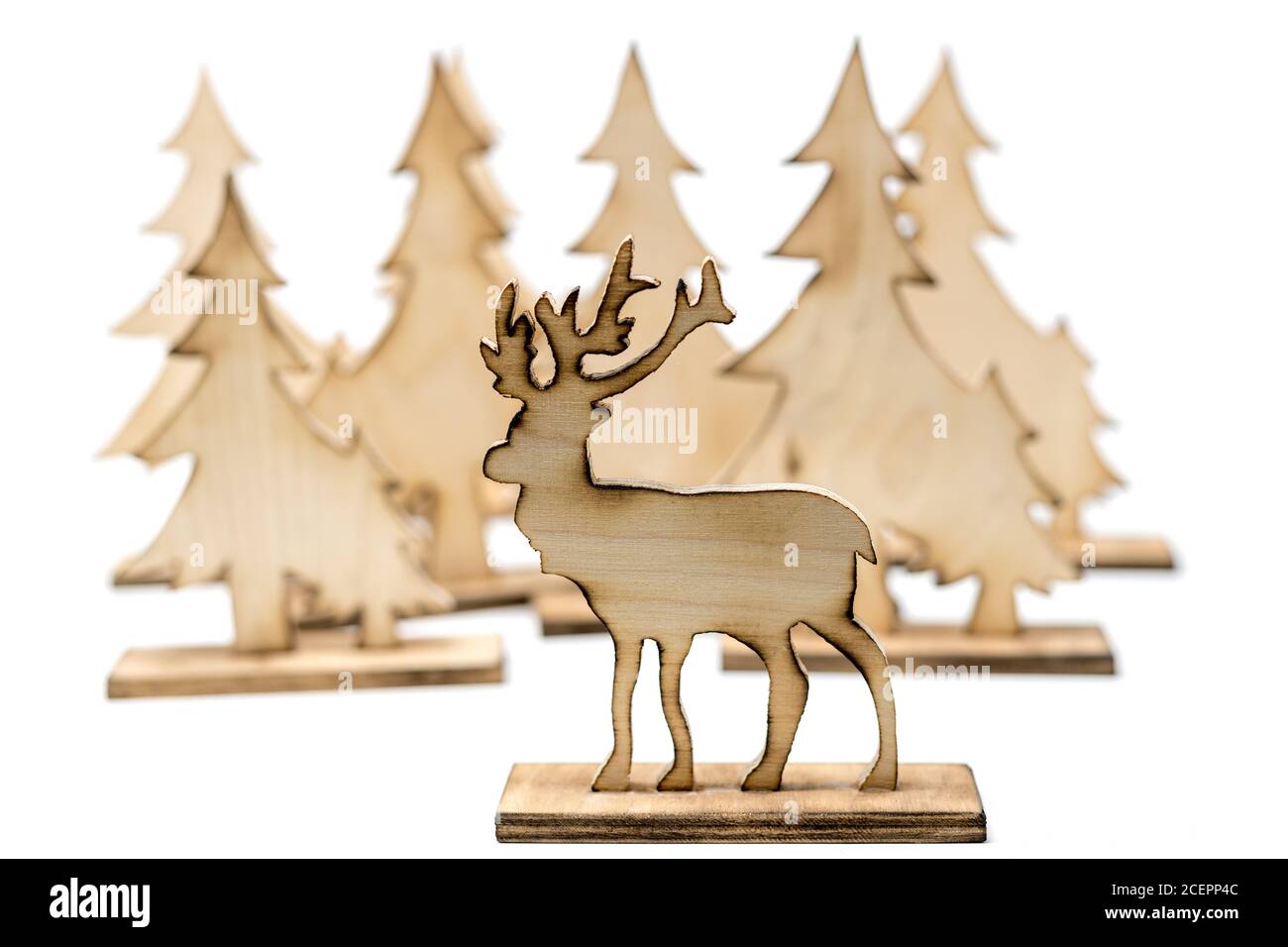 Cut out deer figure made of wood with dark edges and wooden fir trees ...