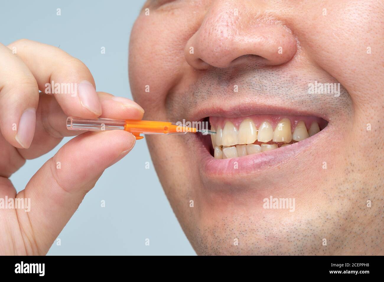Man cleaning his teeth with an interdental brush Stock Photo - Alamy