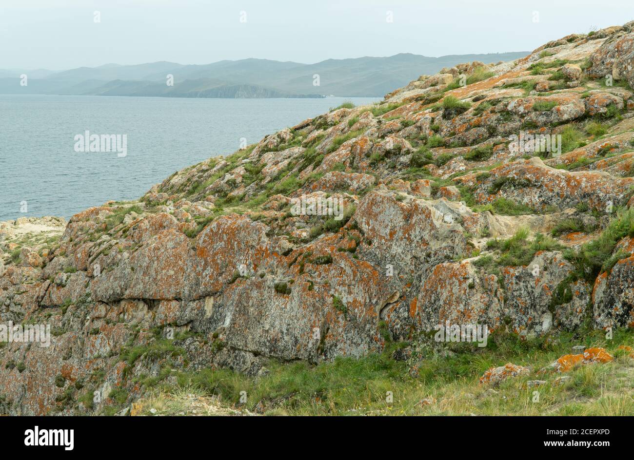 rocks on the lake shore are covered with bright red lichen Stock Photo ...