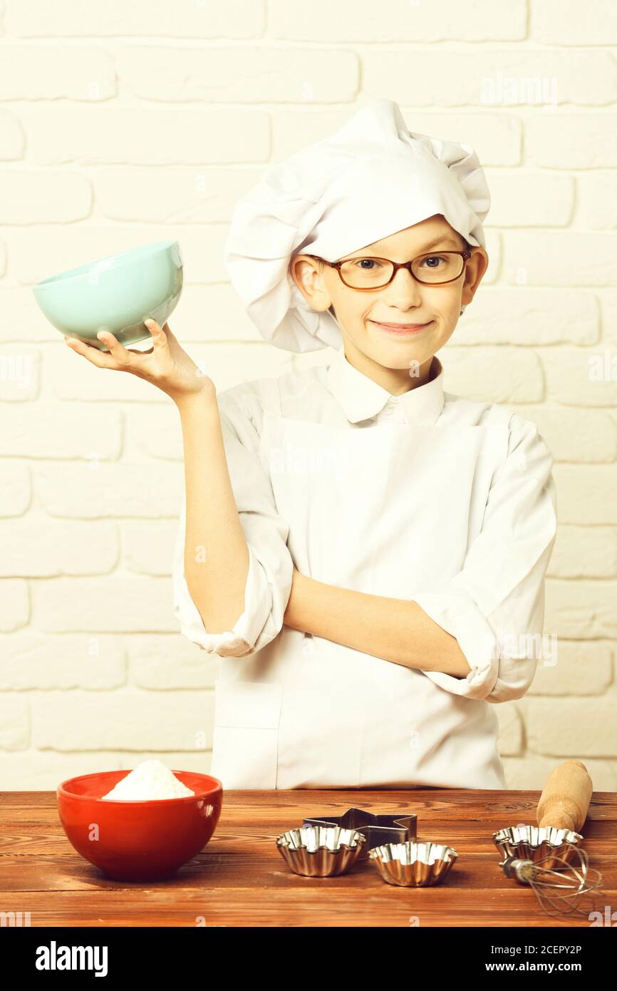 young boy small cute cook chef in white uniform and hat on smiling face ...