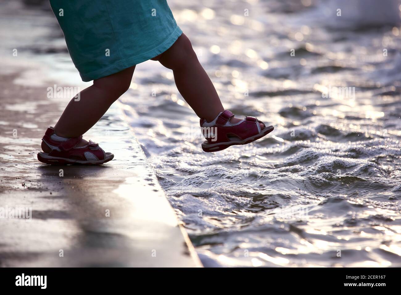 the child steps into the water Stock Photo - Alamy