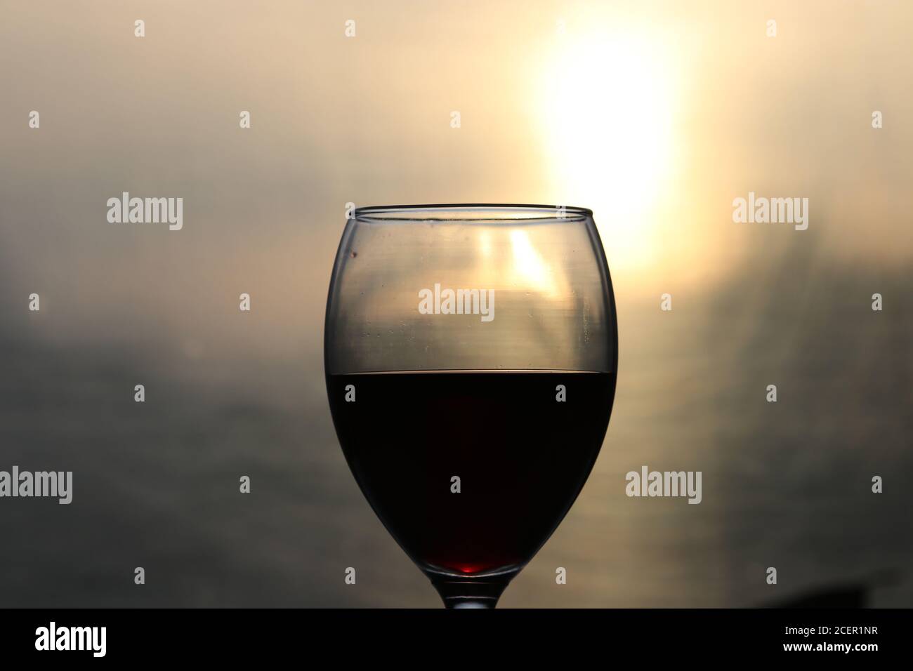 Glass of Red Wine with sun behind Stock Photo - Alamy