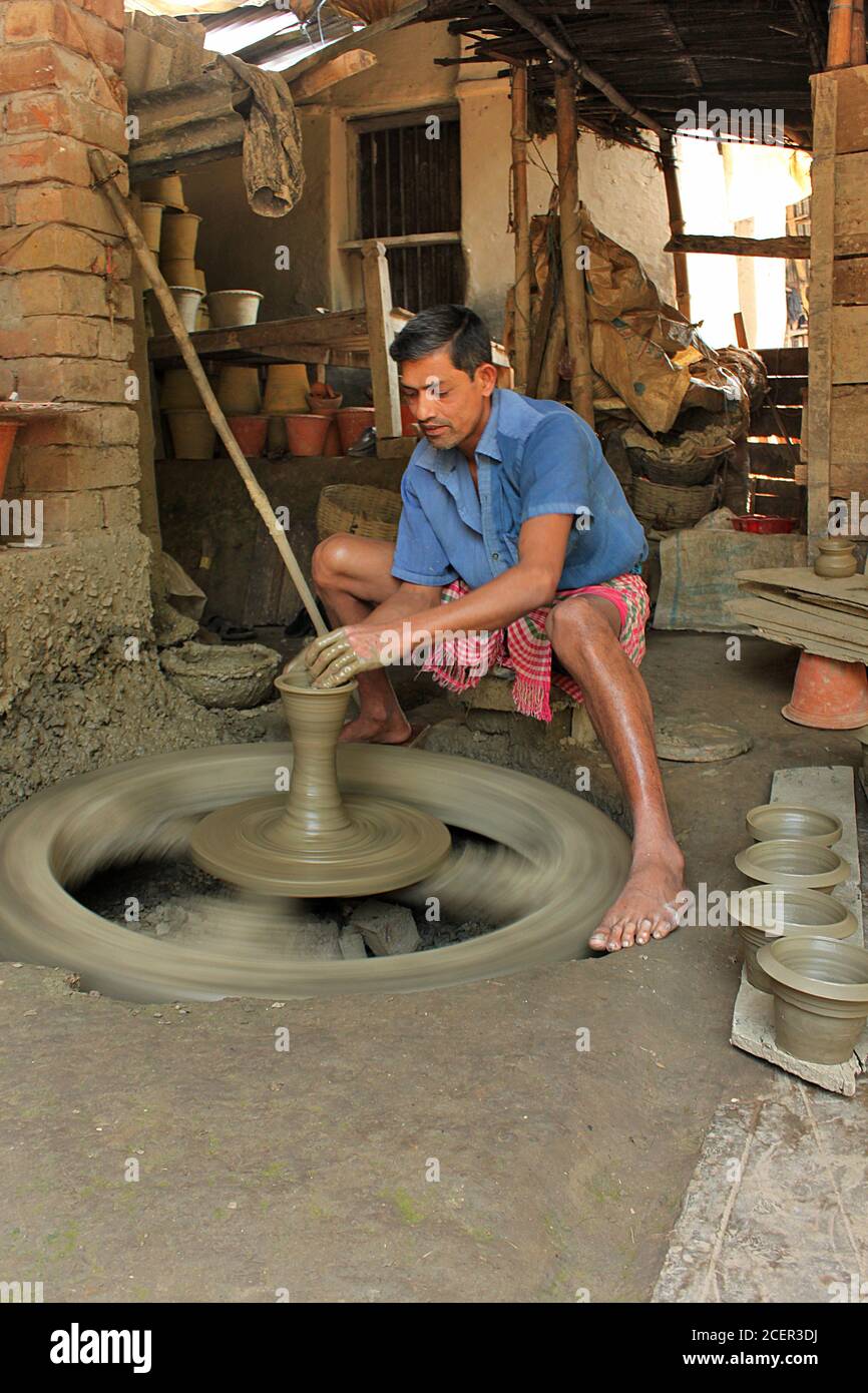 Potter makes clay pot using a traditional wheel at rural village in ...
