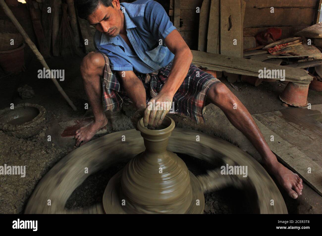 Potter makes clay pot using a traditional wheel at rural village in ...