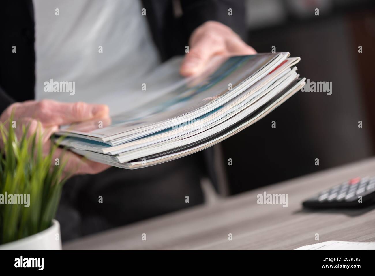 Male hands holding a stack of magazines Stock Photo - Alamy