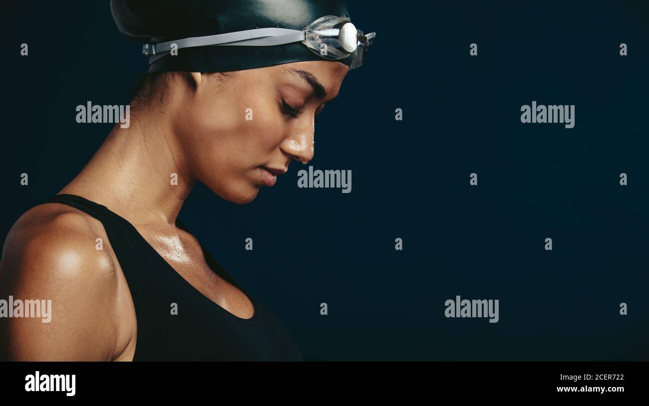 Close-up of a woman swimmer looking tired after a race. Female wearing ...