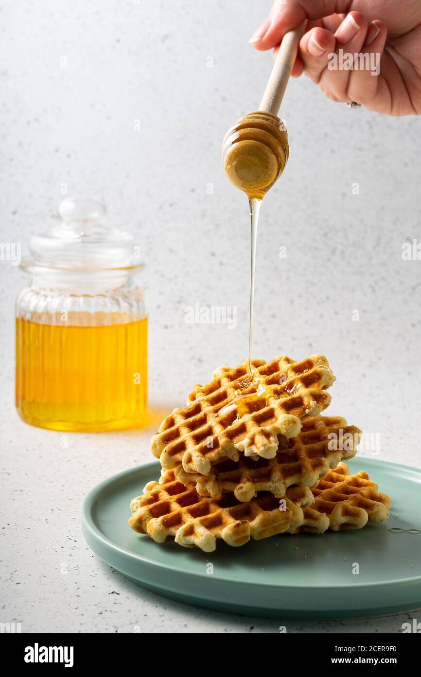 selective focus, Belgian sugar waffles with flower honey on a blue ...