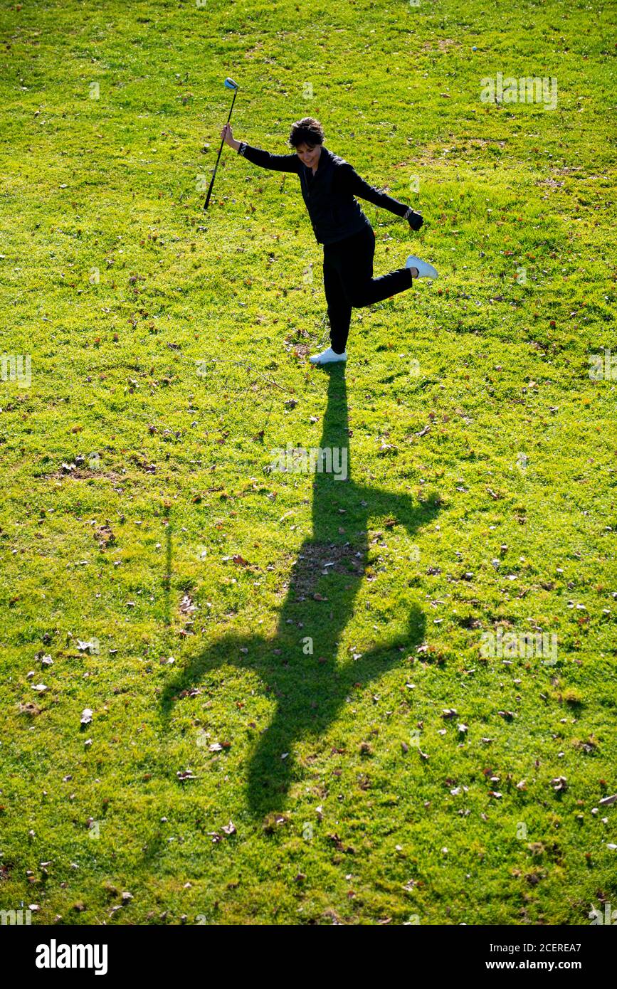 Golfer with Success Holding Golf Club and Ball and Standing on One Leg ...