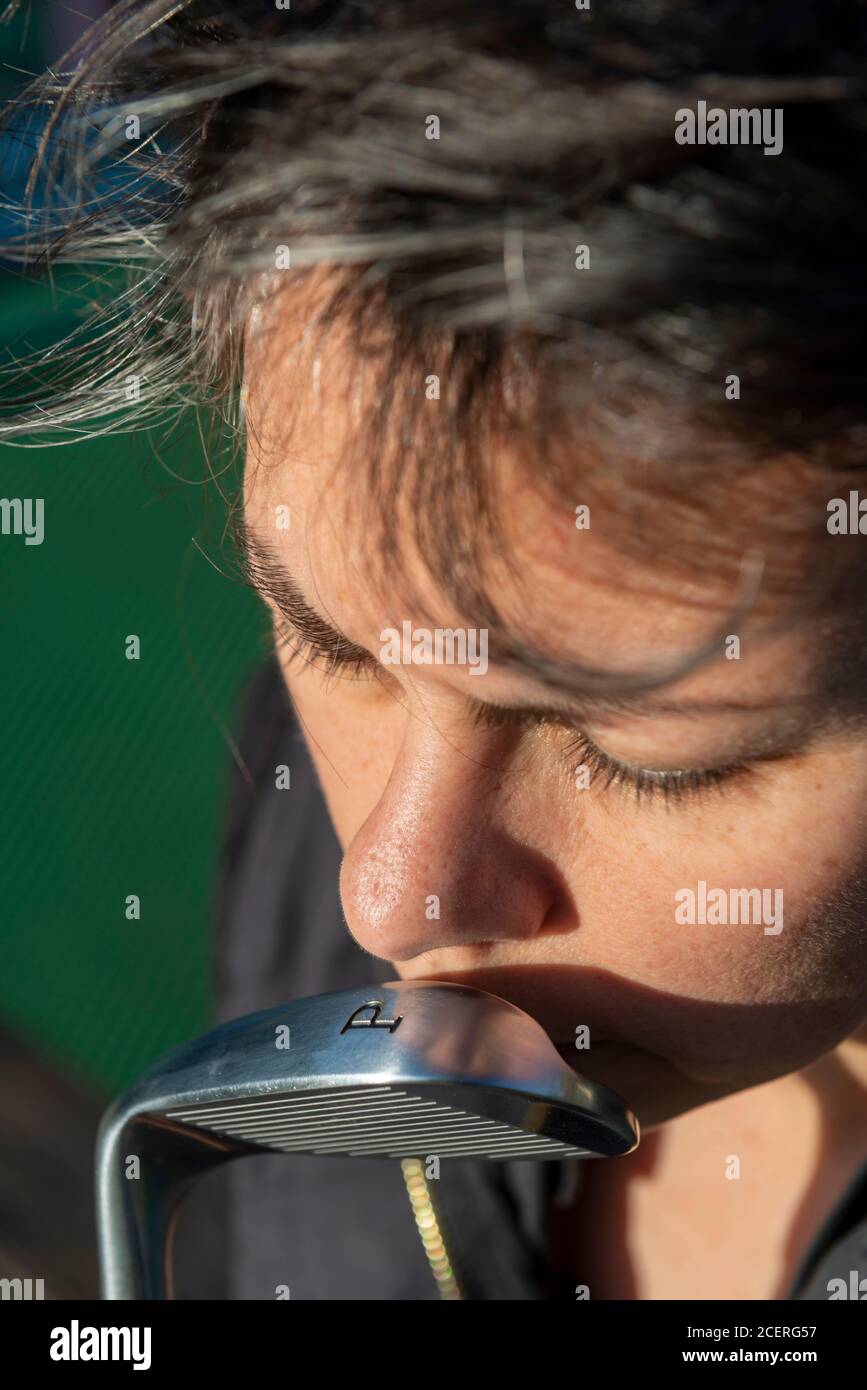 Golfer Holding Her Golf Club in Front of Her Face Stock Photo - Alamy