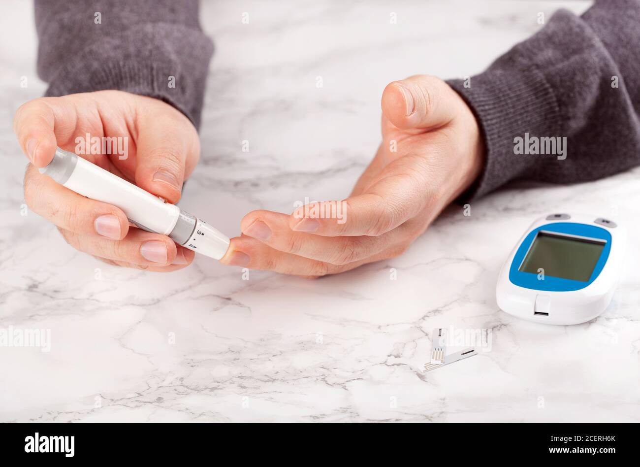 man hands using lancet on finger to check blood sugar or ketones level ...
