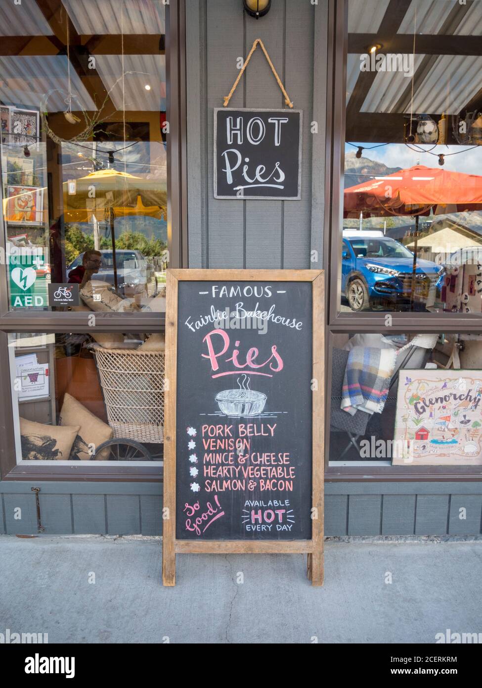 A sign advertising Fairlie bakery pies and the shop window at a cafe in ...