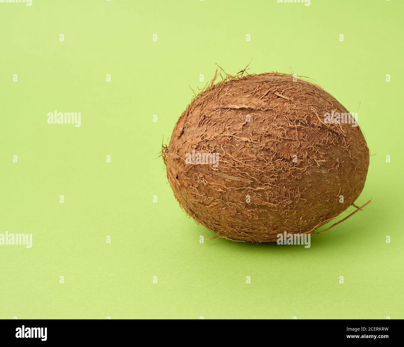 ripe whole round coconut on a green background, close up Stock Photo ...