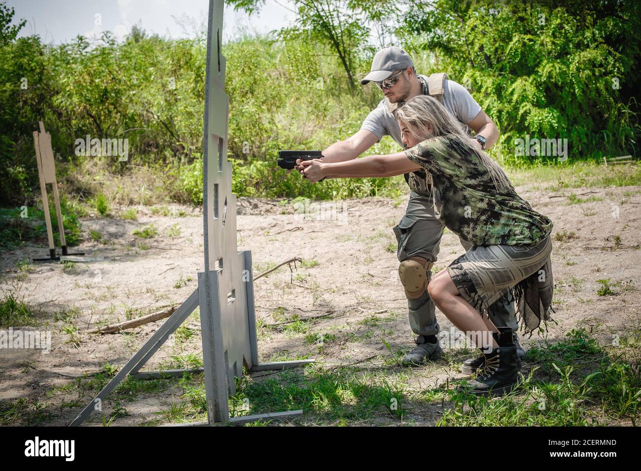 Instructor on shooting range teaches his female student tactical gun ...