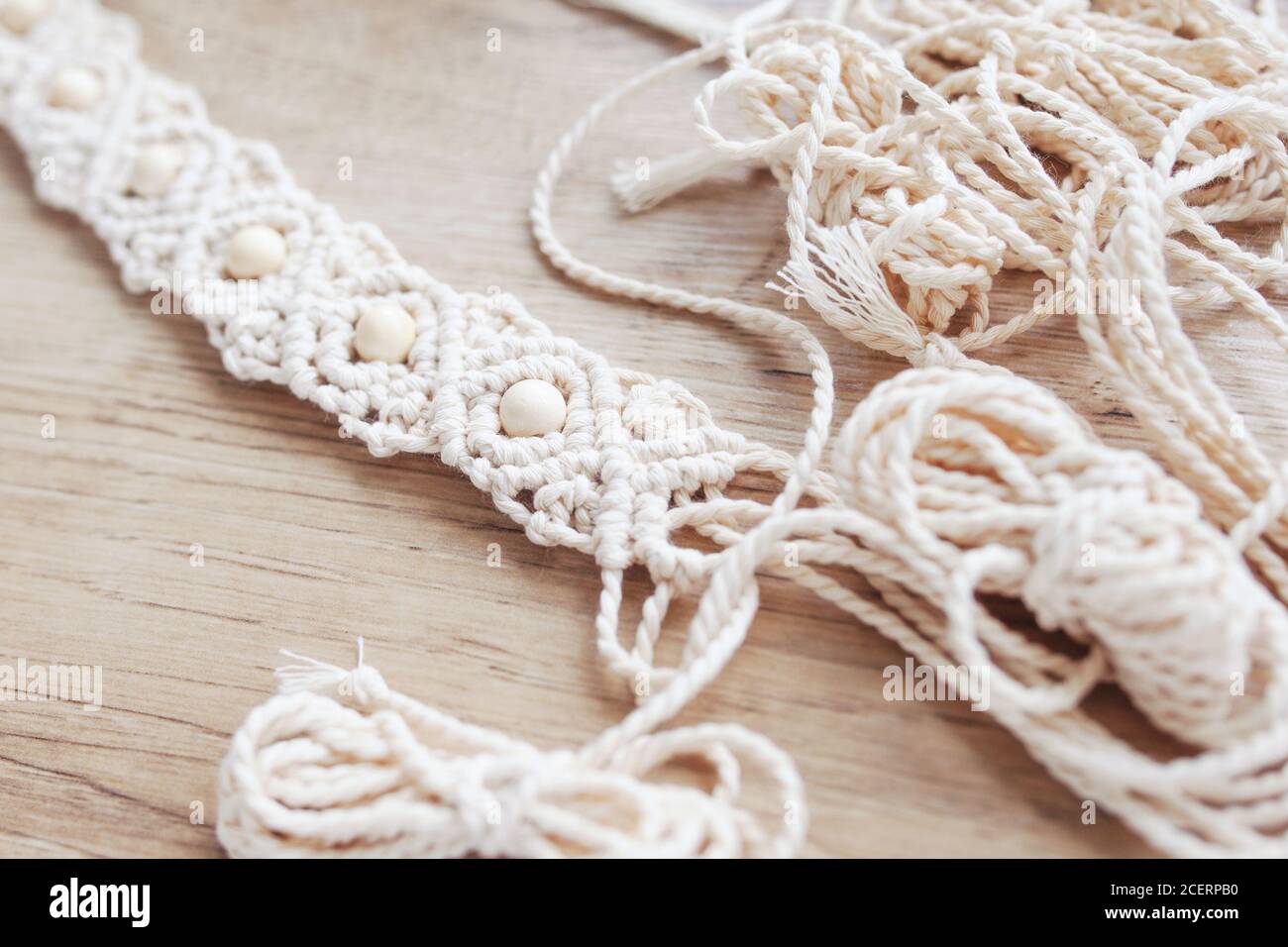 Handmade macrame belt in work process. Natural cotton threads and ...