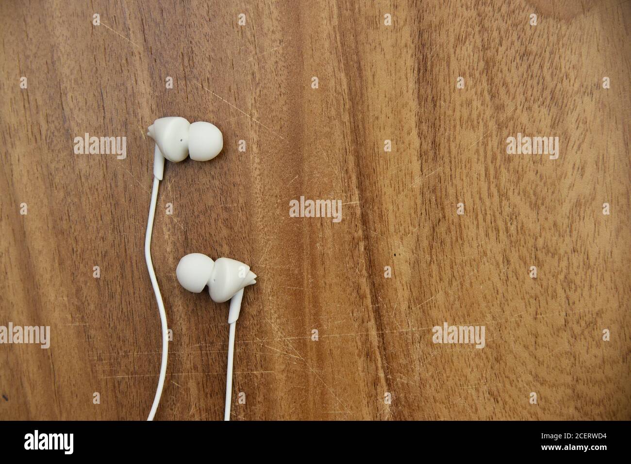 White wired earphone with wooden background with text space Stock Photo ...