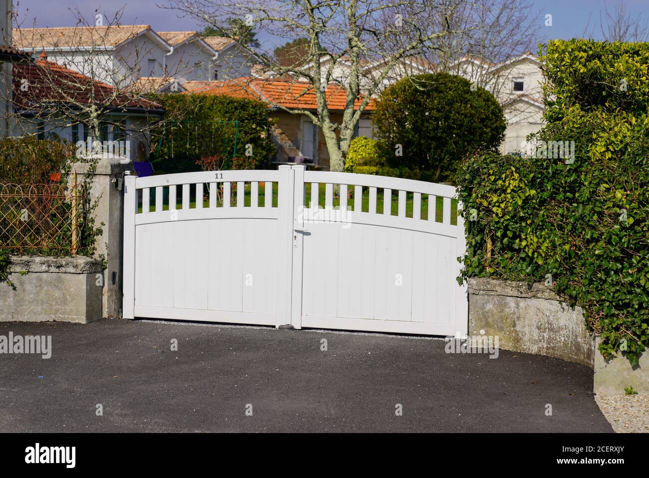 white new metal driveway entrance home gates in modern suburb house ...