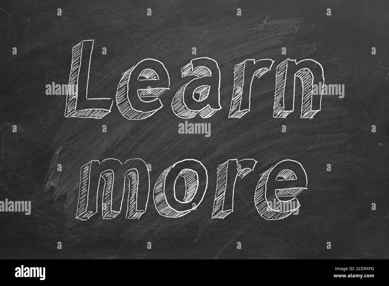 Hand drawing "Learn more" on black chalkboard Stock Photo - Alamy