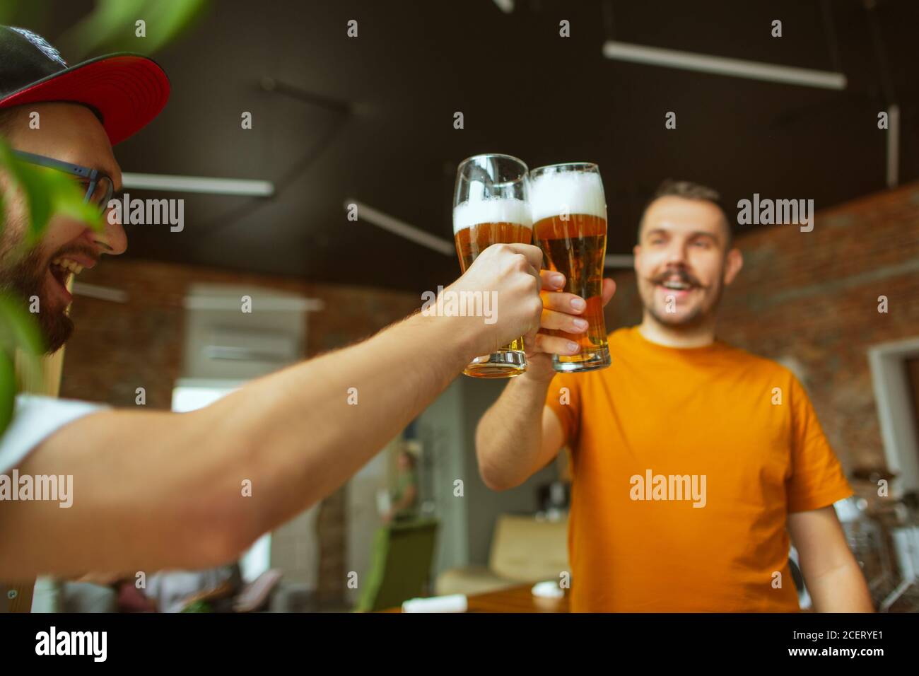 Clinking bottles. Young group of friends drinking beer, having fun ...