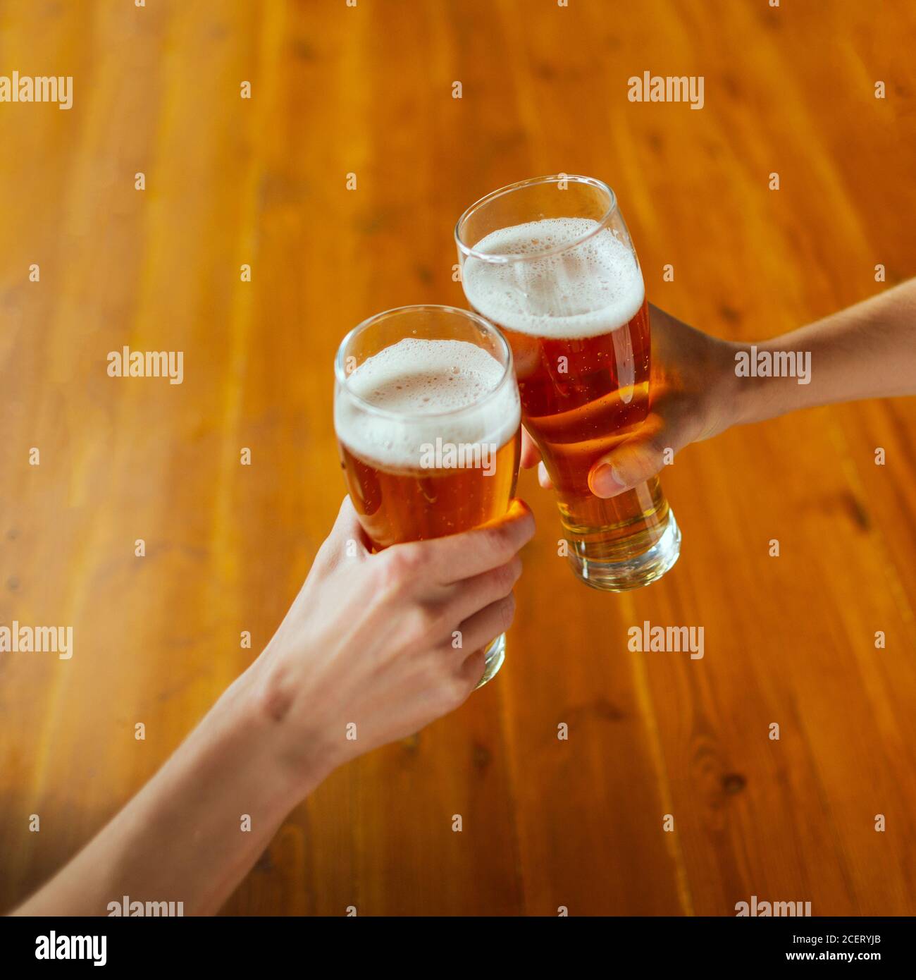 Close up clinking. Young group of friends drinking beer, having fun ...